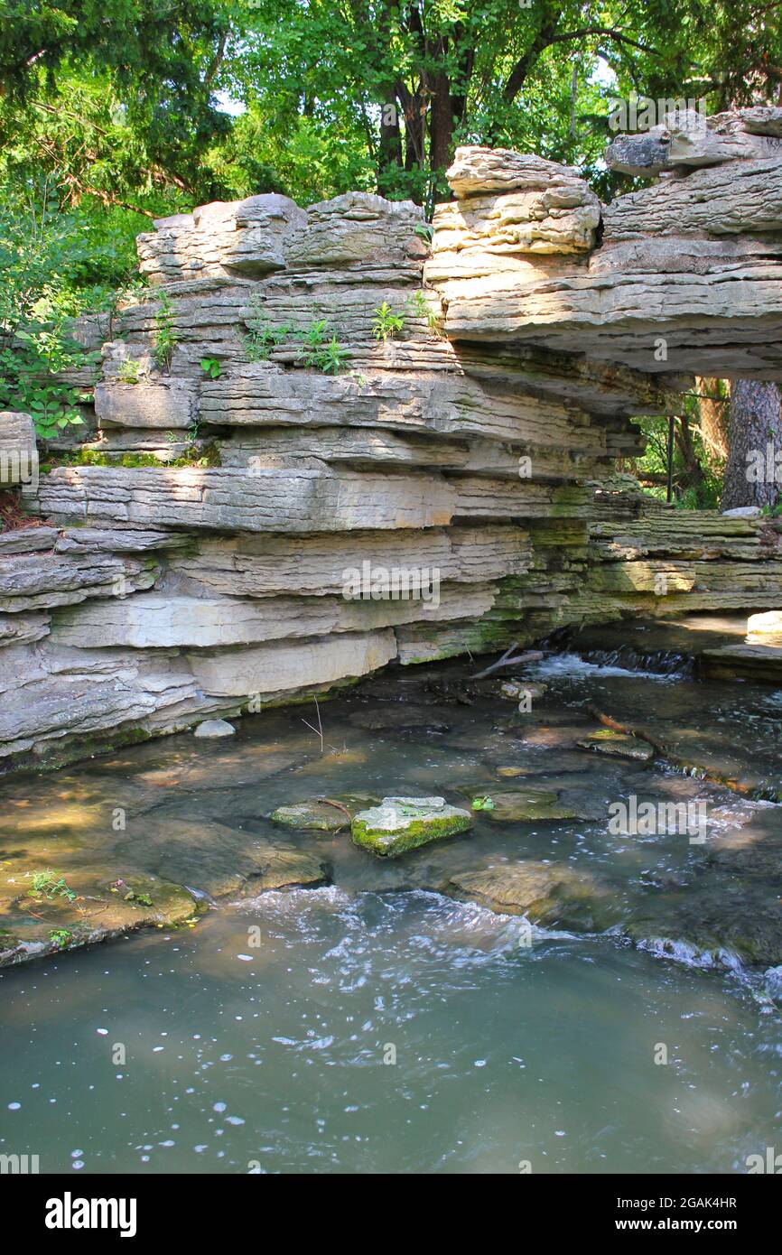 Sedimentary field stone layers of rock forming a wall at the park on a ...