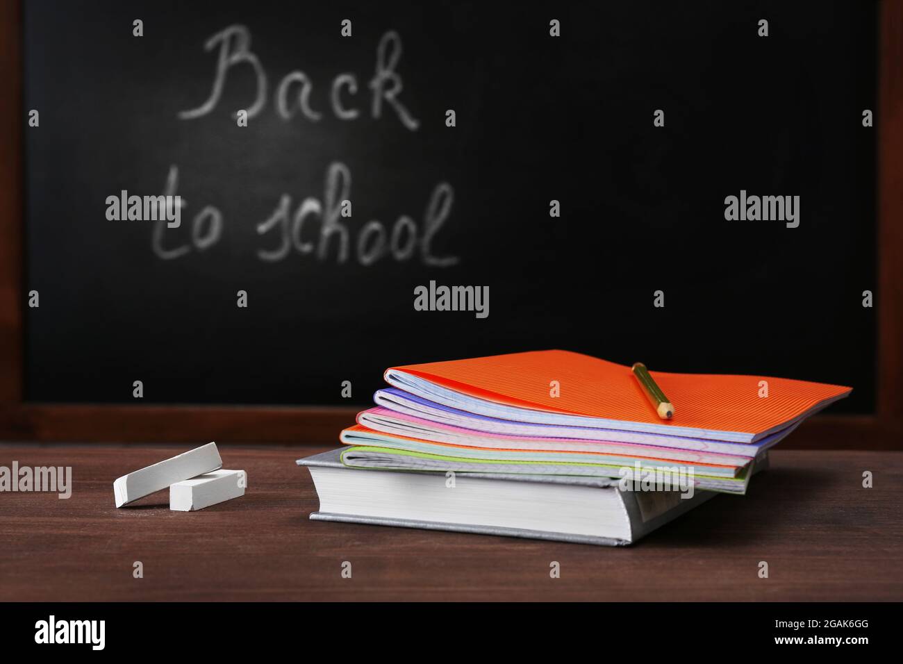 School equipment on desk on blackboard background Stock Photo - Alamy