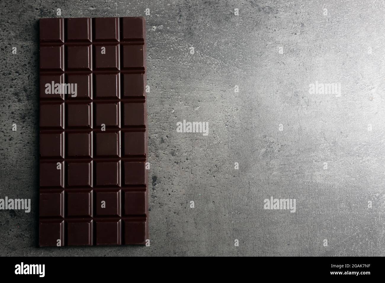 Chocolate bar on dark grey background Stock Photo - Alamy