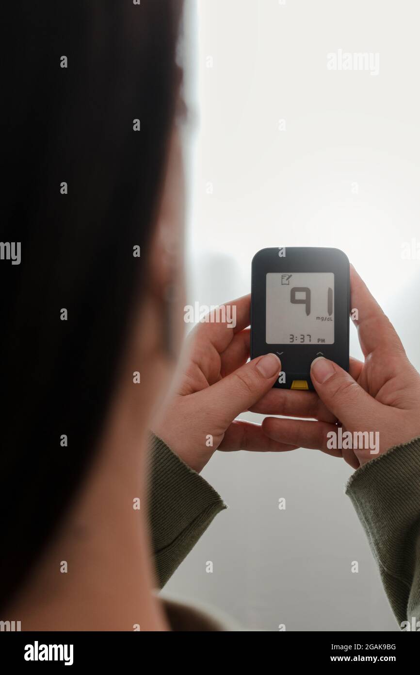 close-up shot from the back of a Latina woman using a glucometer Stock ...