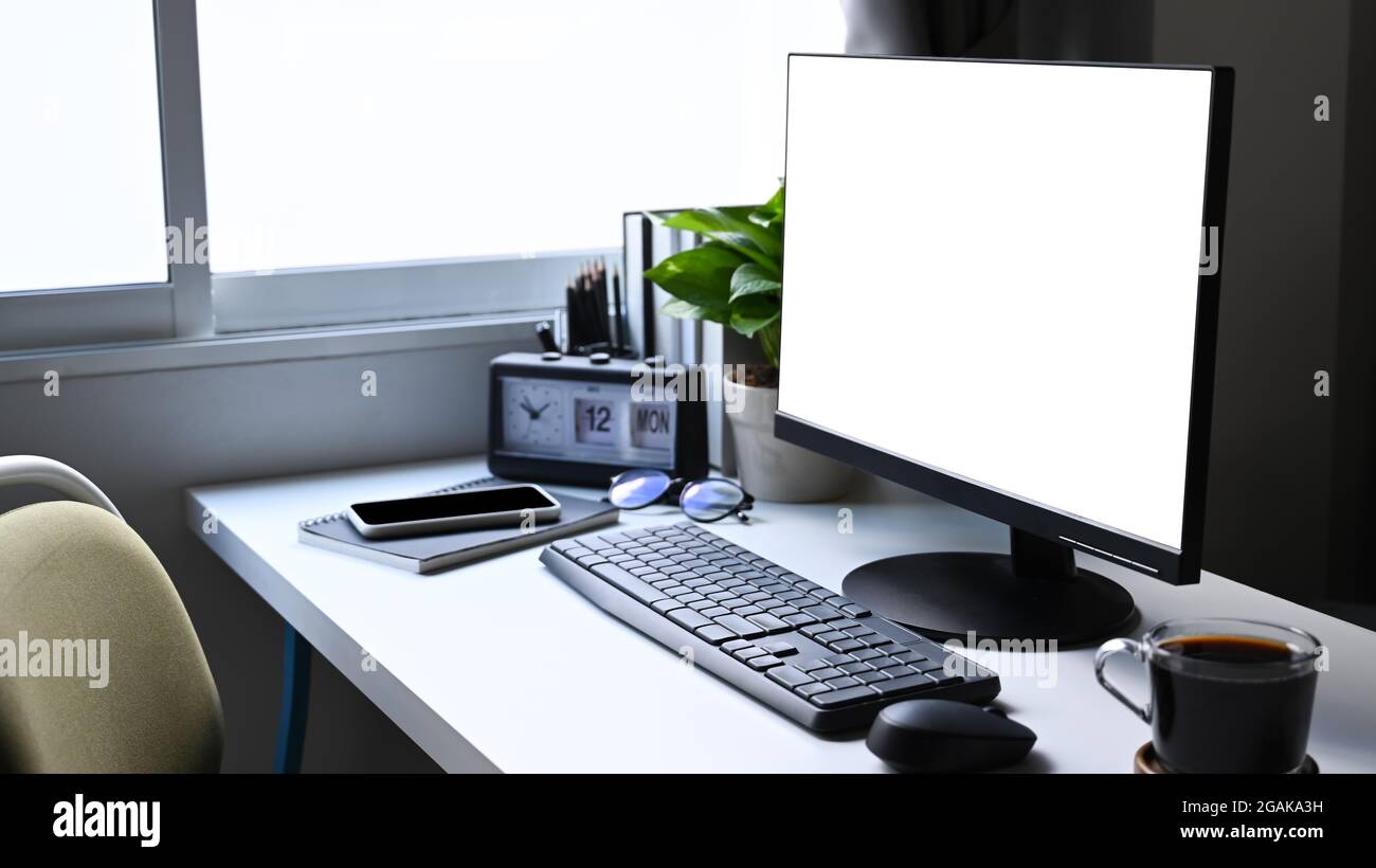 Computer with blank screen and supplies on white table Stock Photo - Alamy