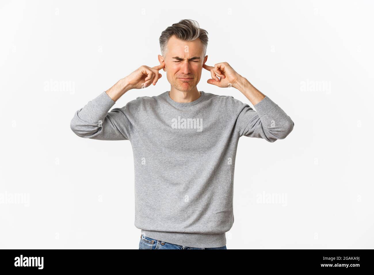 Portrait of annoyed and distressed middle-aged man, grimacing from loud ...