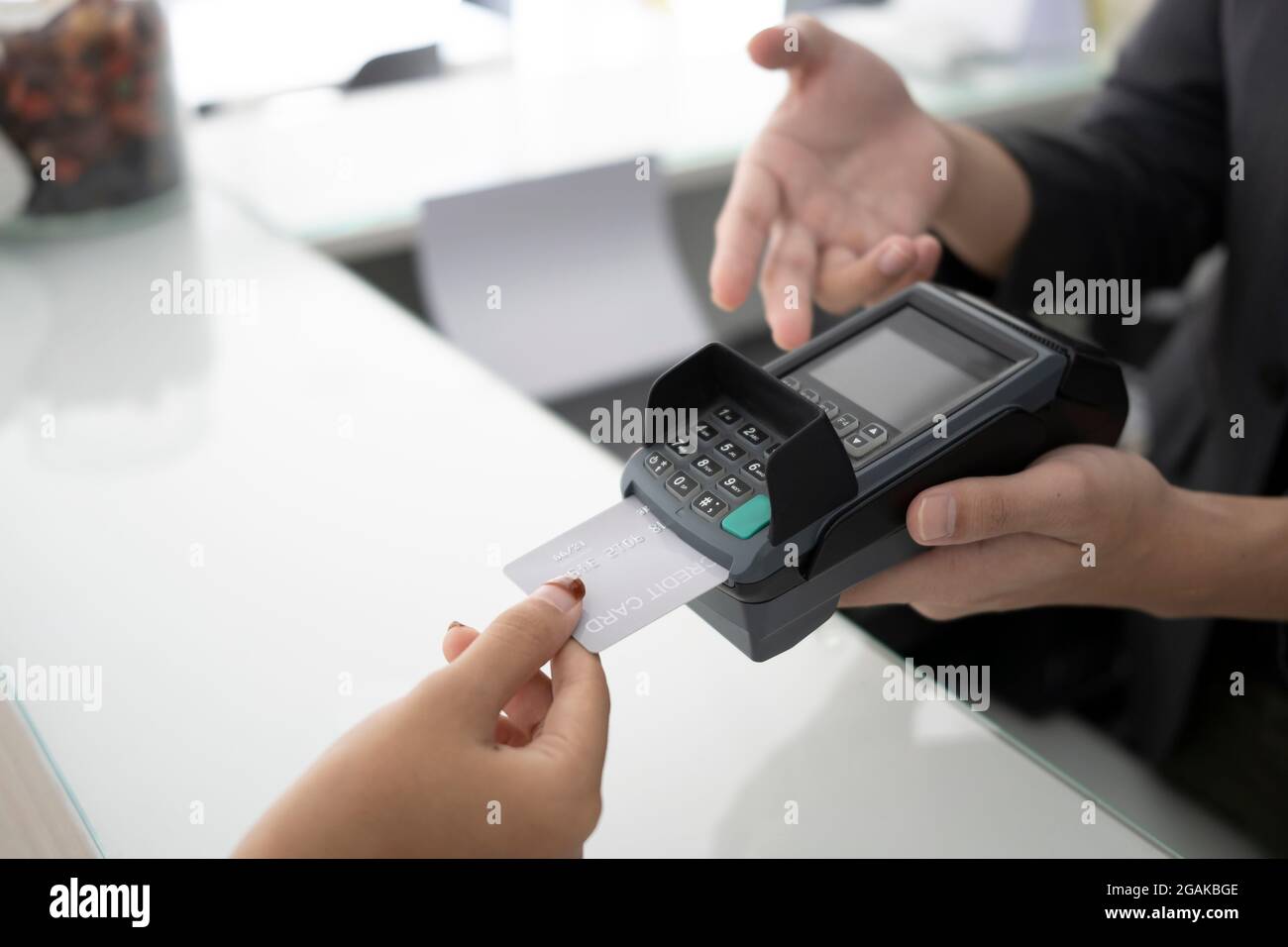 Customer standing near bar counter and making payment with credit card ...