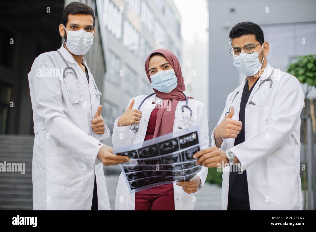 Team of three young diverse experts doctors in uniforms scrubs and ...