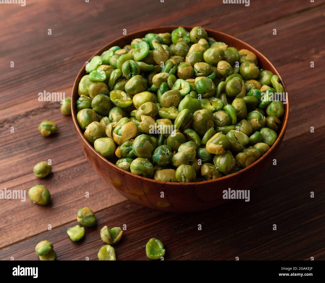 Salted green peas in wooden bowl on the table, Healthy snack ...
