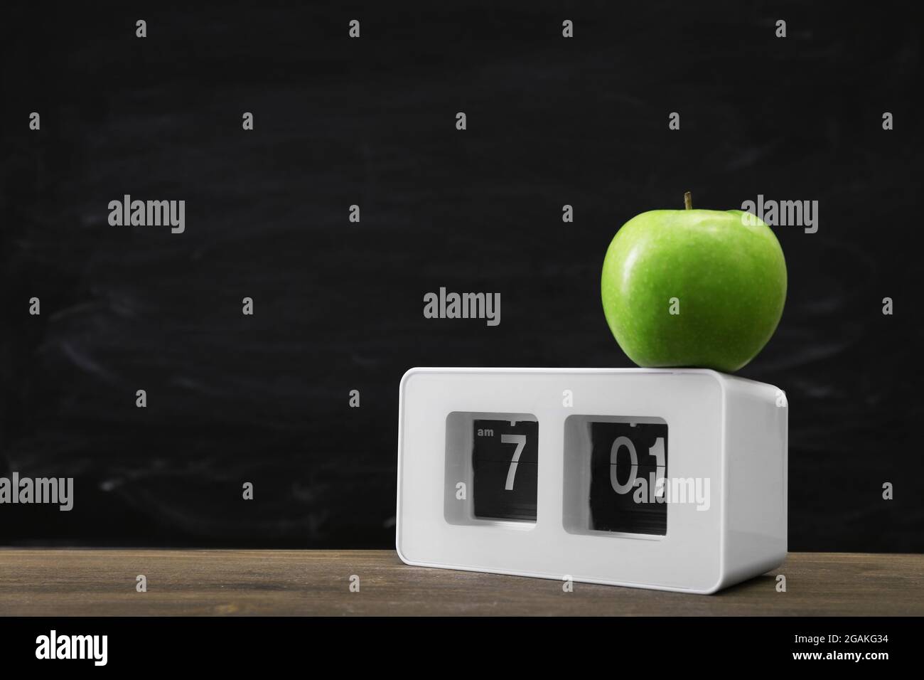 Green apple and clock on blackboard background Stock Photo - Alamy