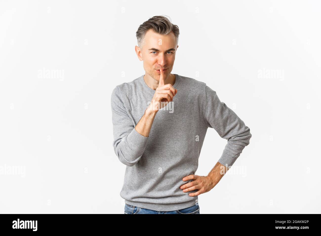 Portrait of cunning handsome man with gray hair, hushing and smiling ...