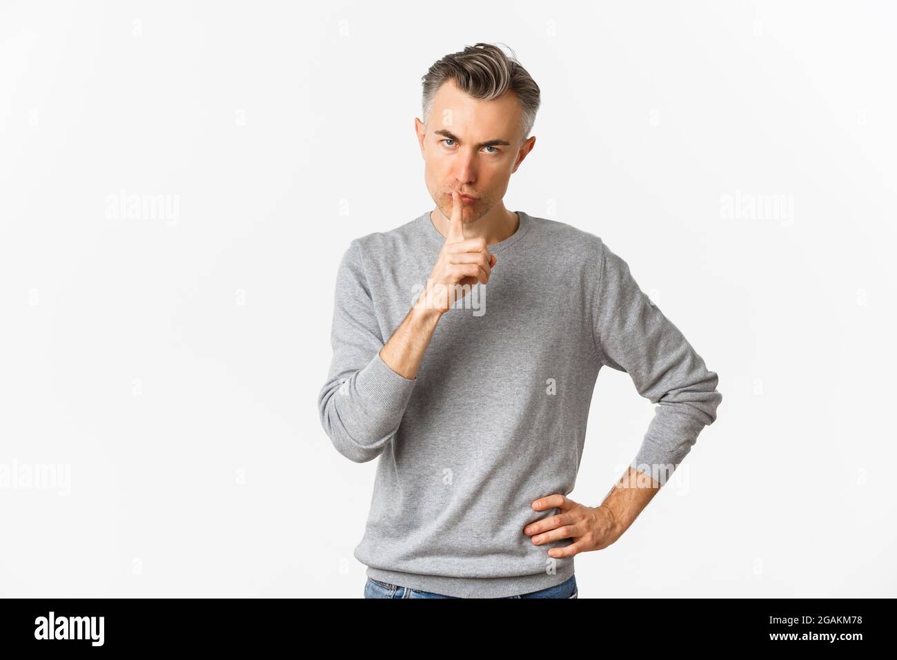 Disappointed middle-aged man with grey hair, hushing at you, scolding ...