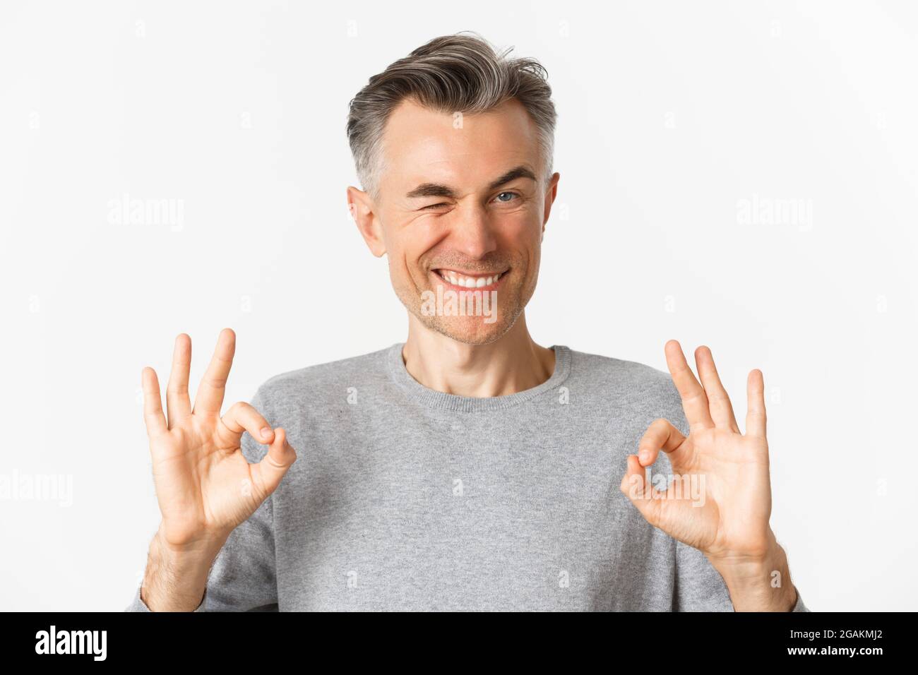 Close-up of handsome and confident middle-aged man, showing okay signs ...