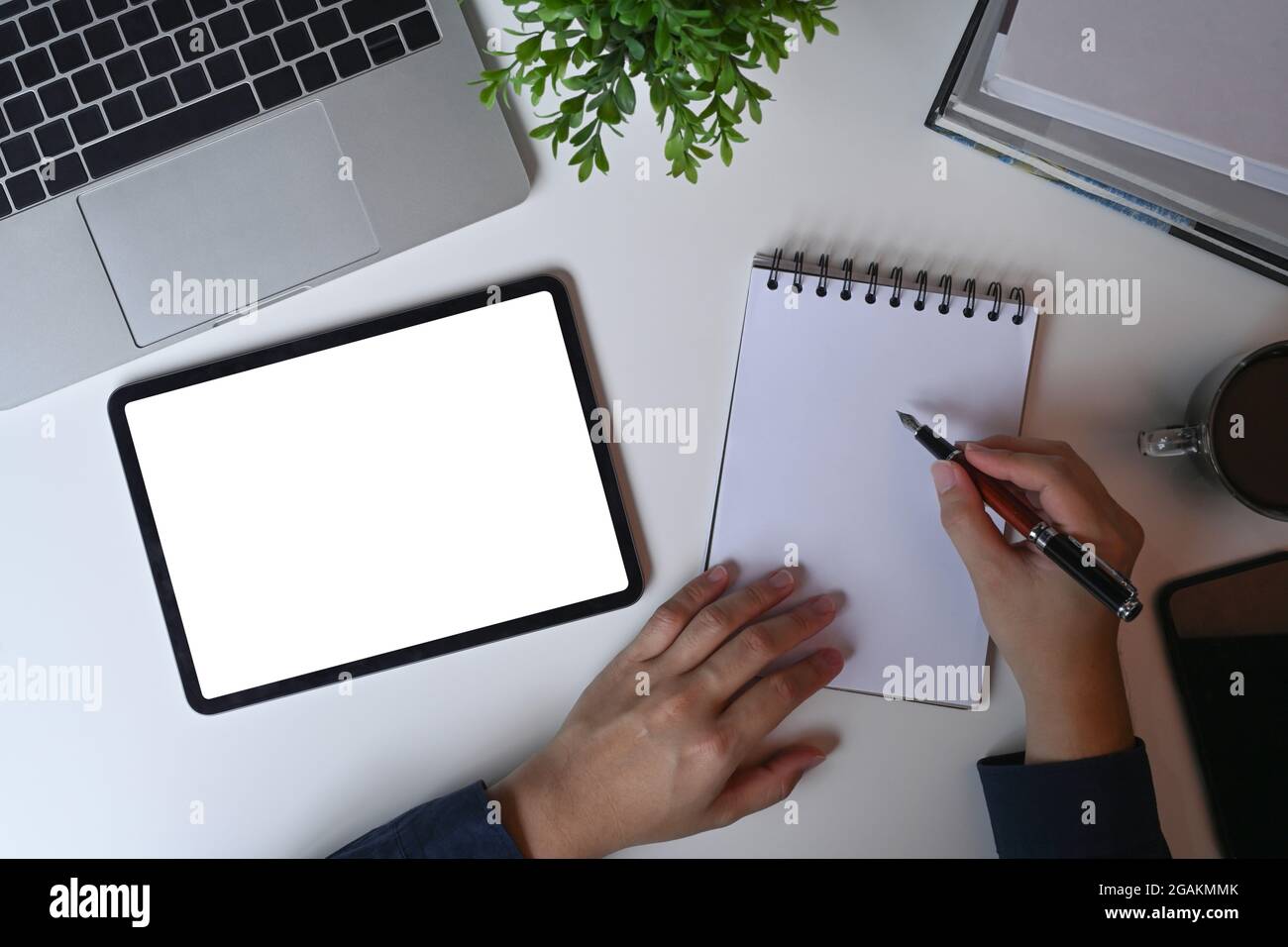 Above view man making note on notepad and using digit tablet Stock ...