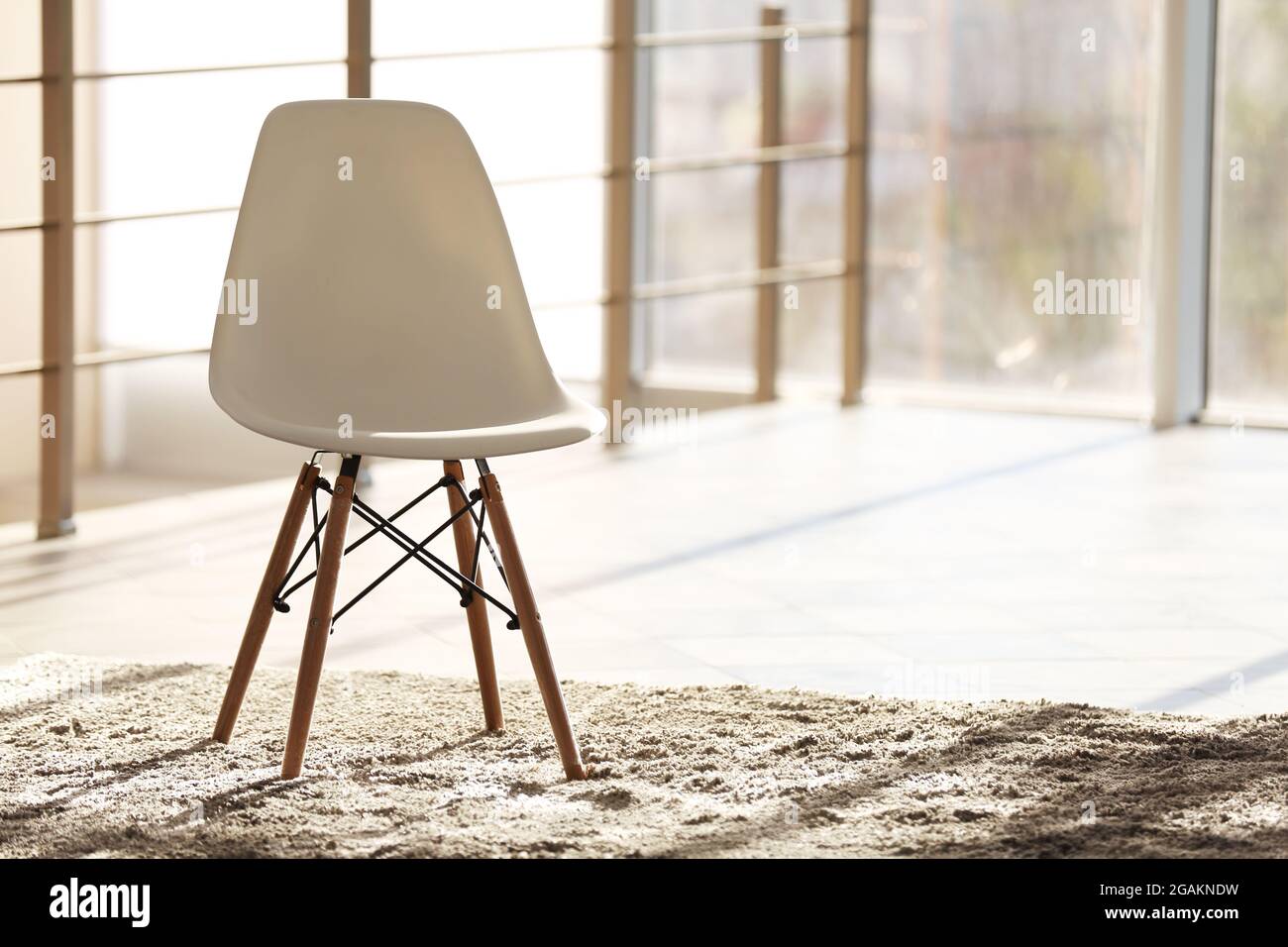 White modern chair in lighted room, on window background Stock Photo ...