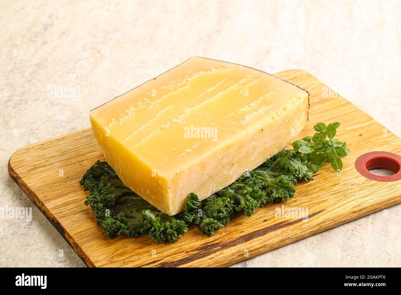 Hard Parmesan cheese piece over board Stock Photo - Alamy