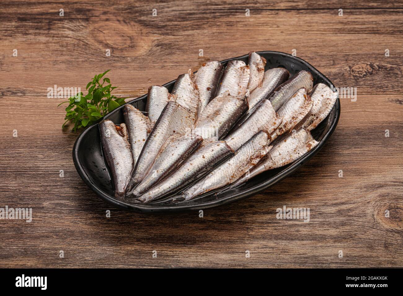 Anchovies fish snack in the bowl served basil leaves Stock Photo - Alamy