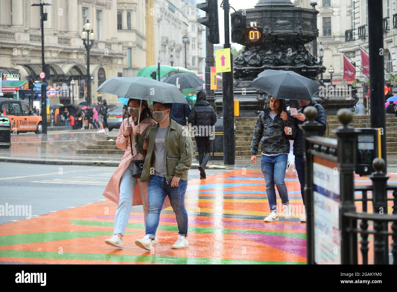 people shelter under umbrellas during a spell of heavy rain Stock Photo ...