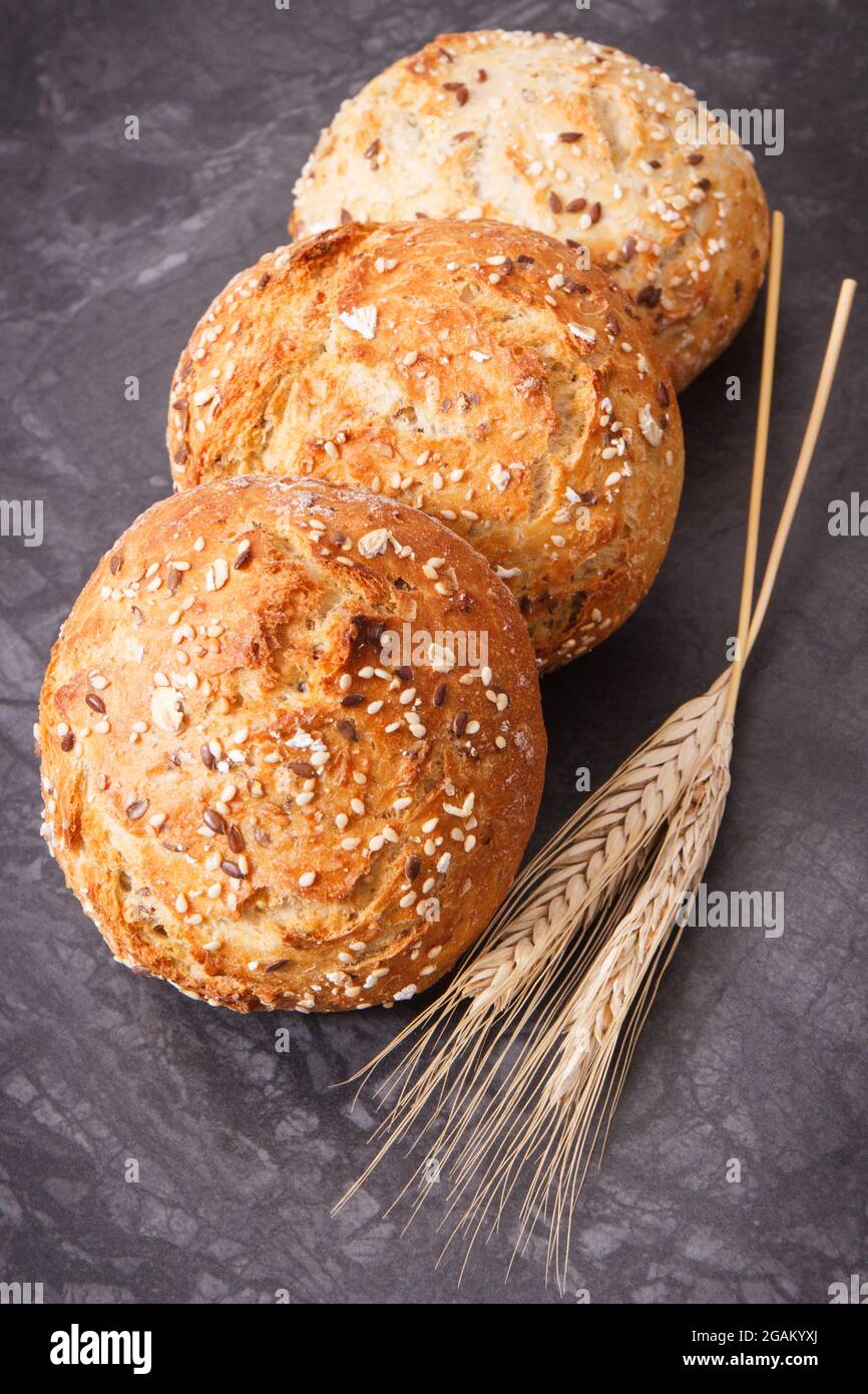 Fresh wholegrain rolls with seeds and ears of rye or wheat grain Stock ...