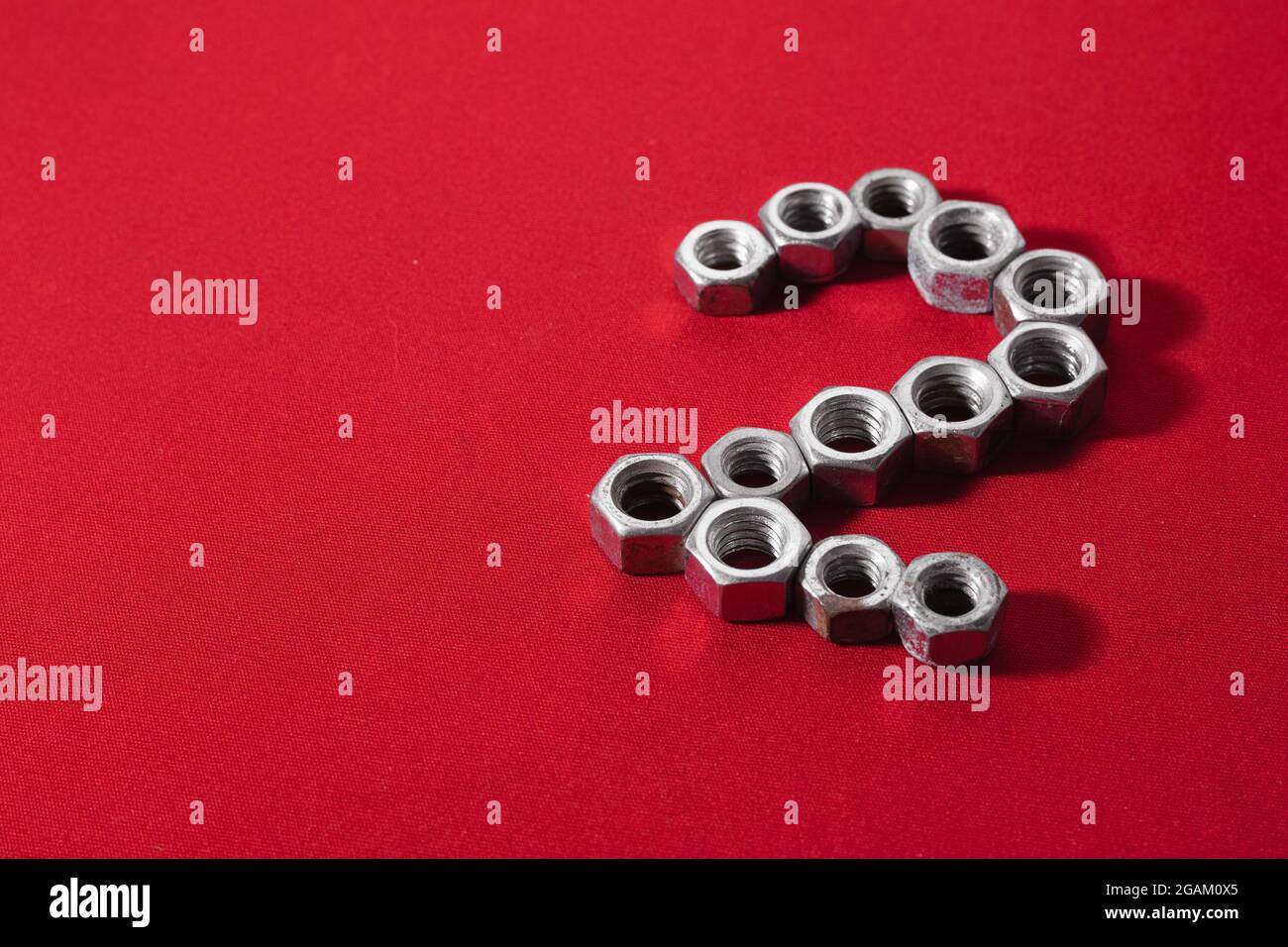 number two, made with steel nuts on red fabric background Stock Photo ...