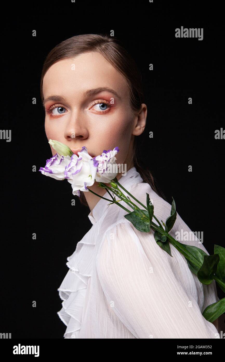 Elegant young female model with delicate flowers Stock Photo - Alamy