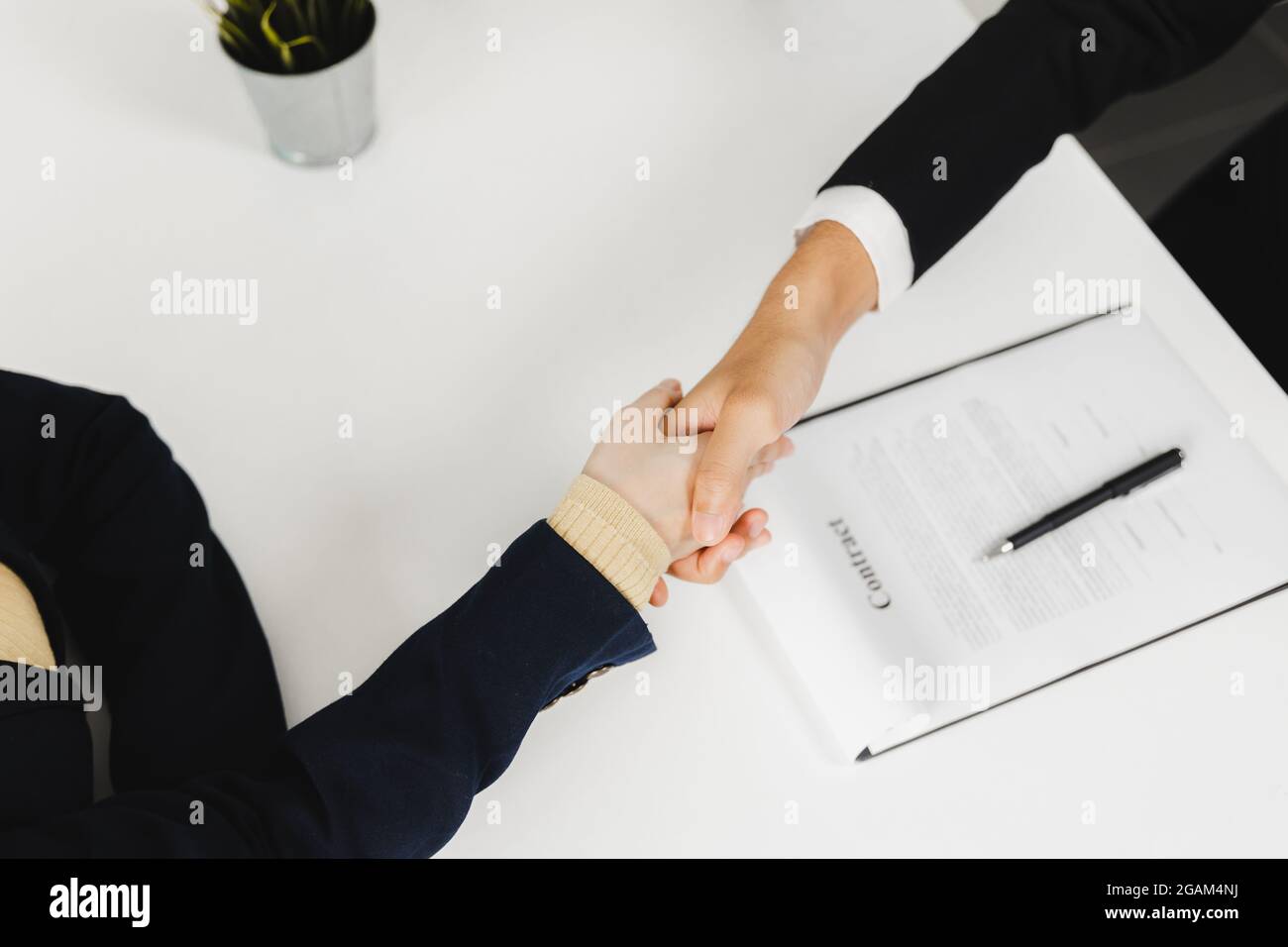 Successful negotiating and business deal, close up top view handshaking ...