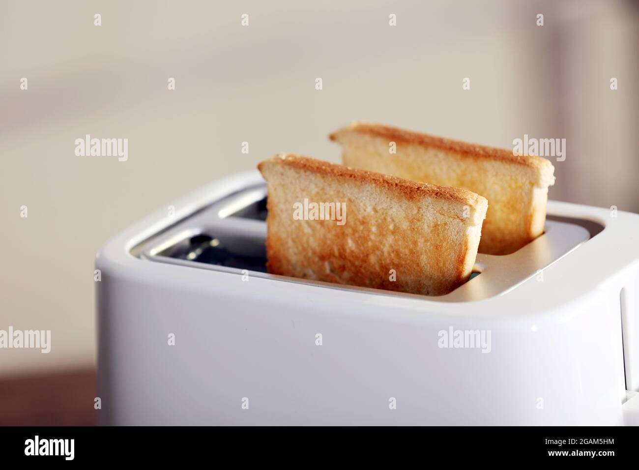 A couple of crusty toasts in the toaster, close-up Stock Photo - Alamy