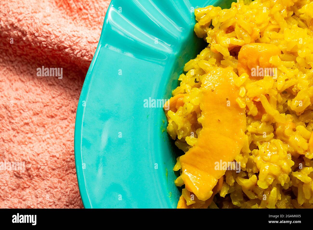 Detail of a green plate filled with rice with pequi pulp. Typical ...