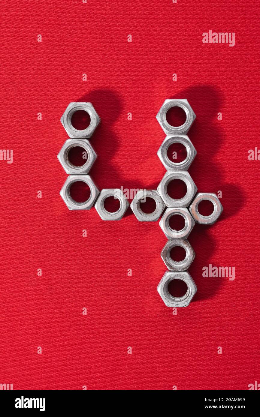 number four, made with steel nuts on red fabric background Stock Photo ...