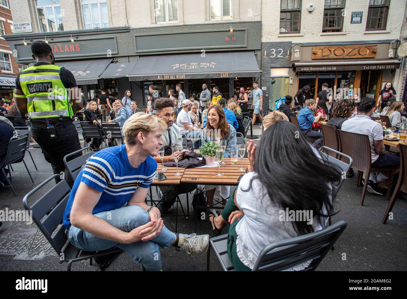 Security watch the crowd of revellers on Old Compton Street as the ...