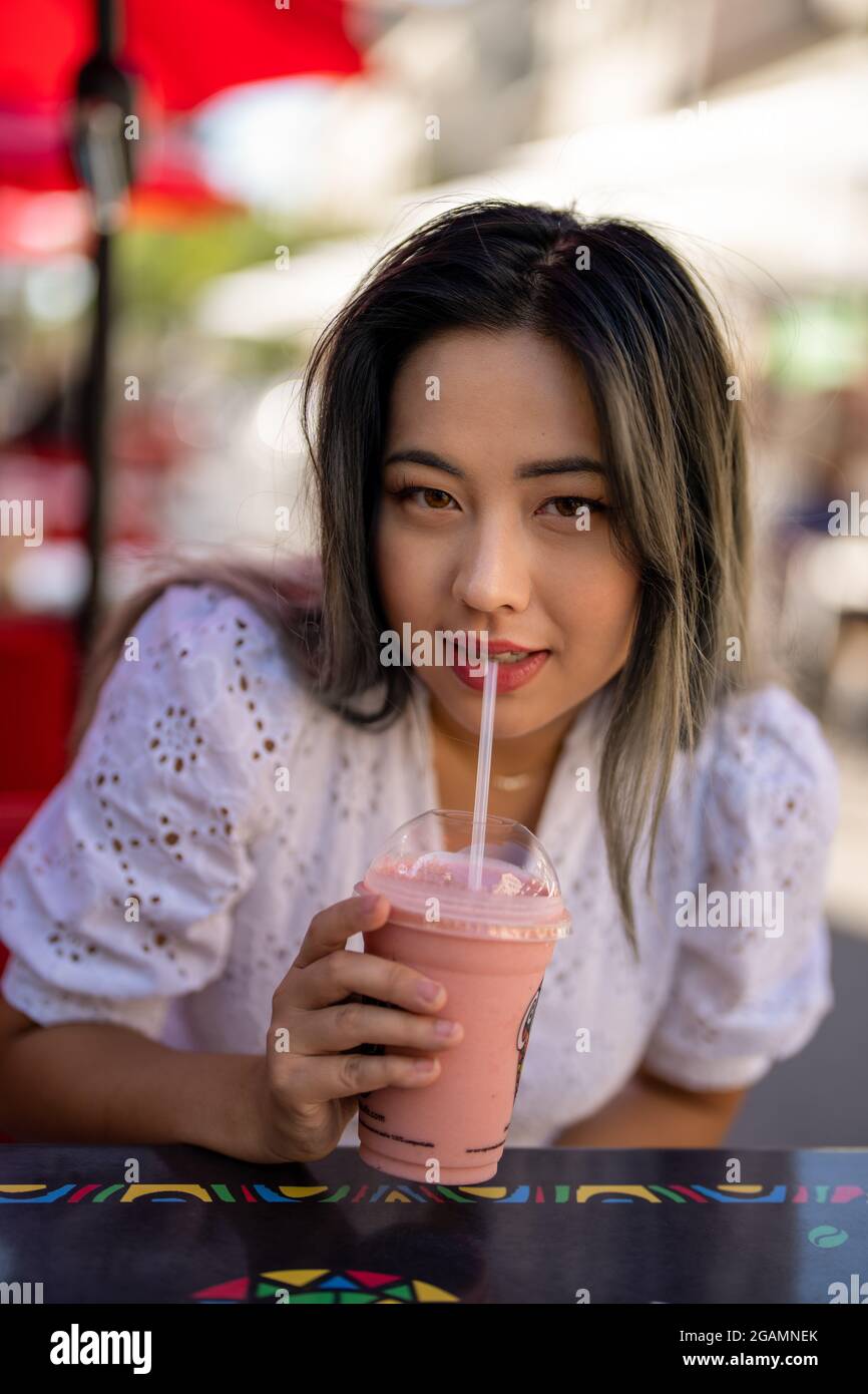 Beautiful Asian Woman Drinking a Strawberry Smoothie Stock Photo - Alamy