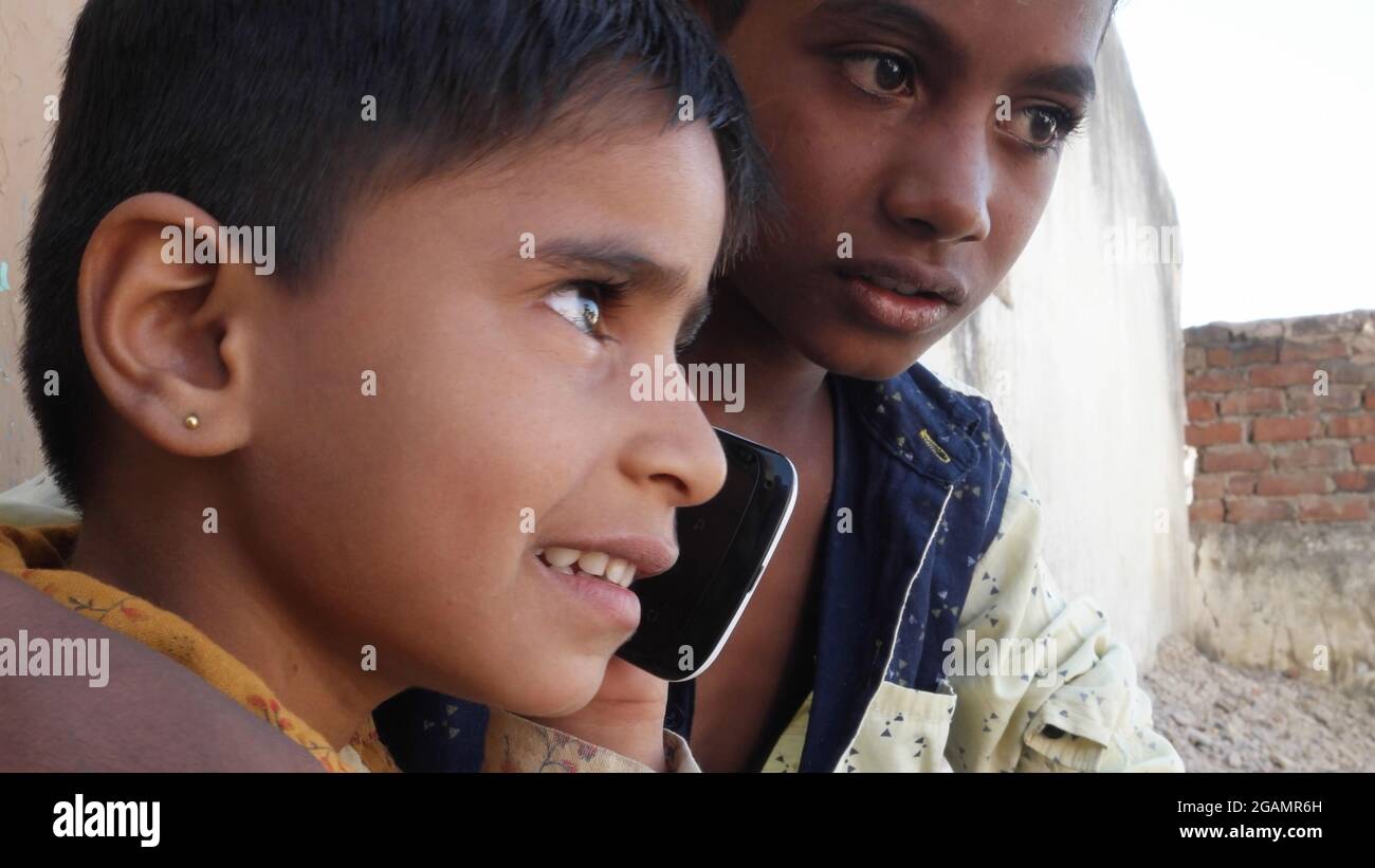 Closeup shot of an Indian male kid talking on the phone Stock Photo - Alamy