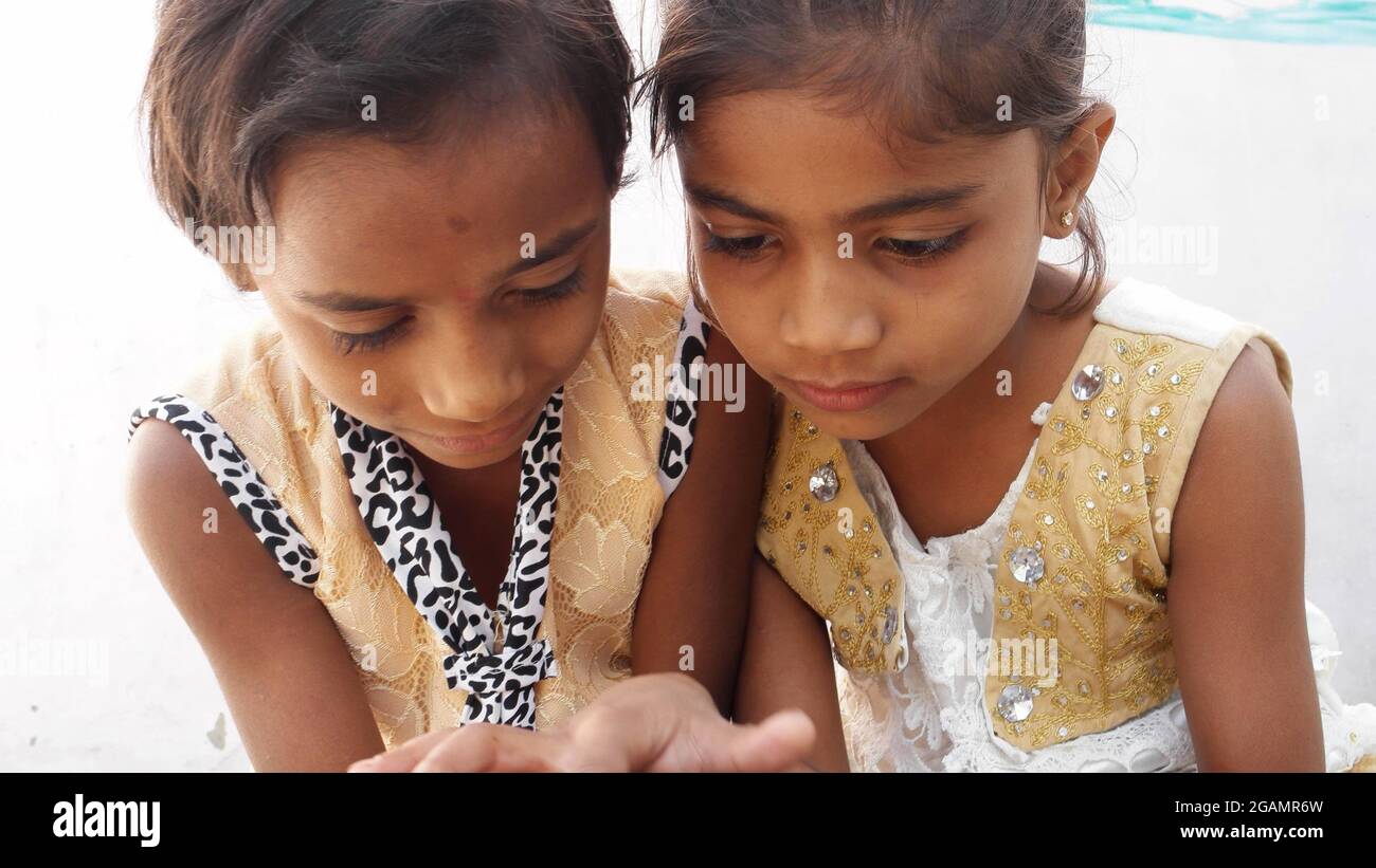 Closeup shot of two Indian female kids looking interested at something ...