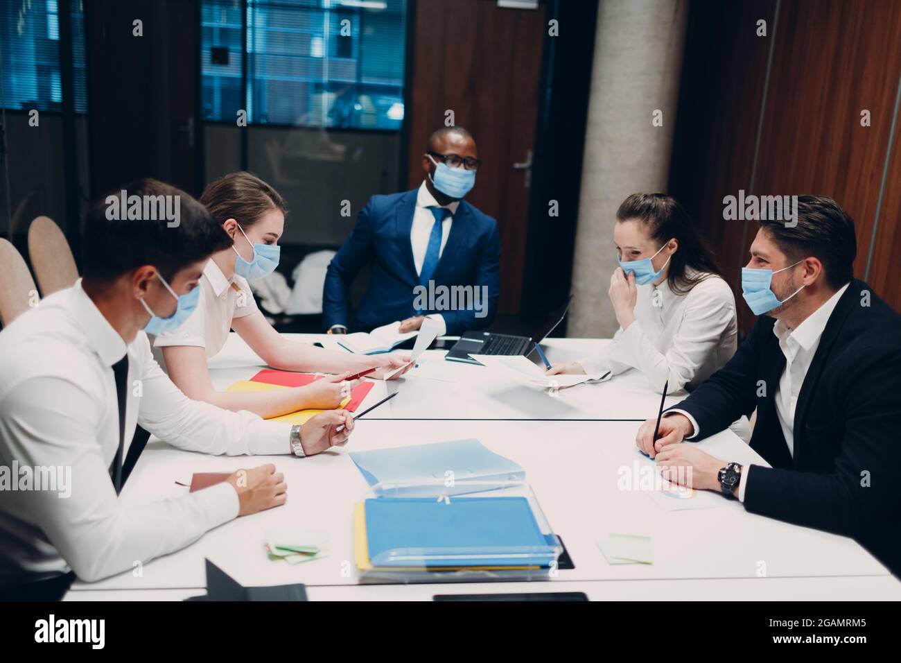 Business team in medical face mask at office meeting. Business people ...