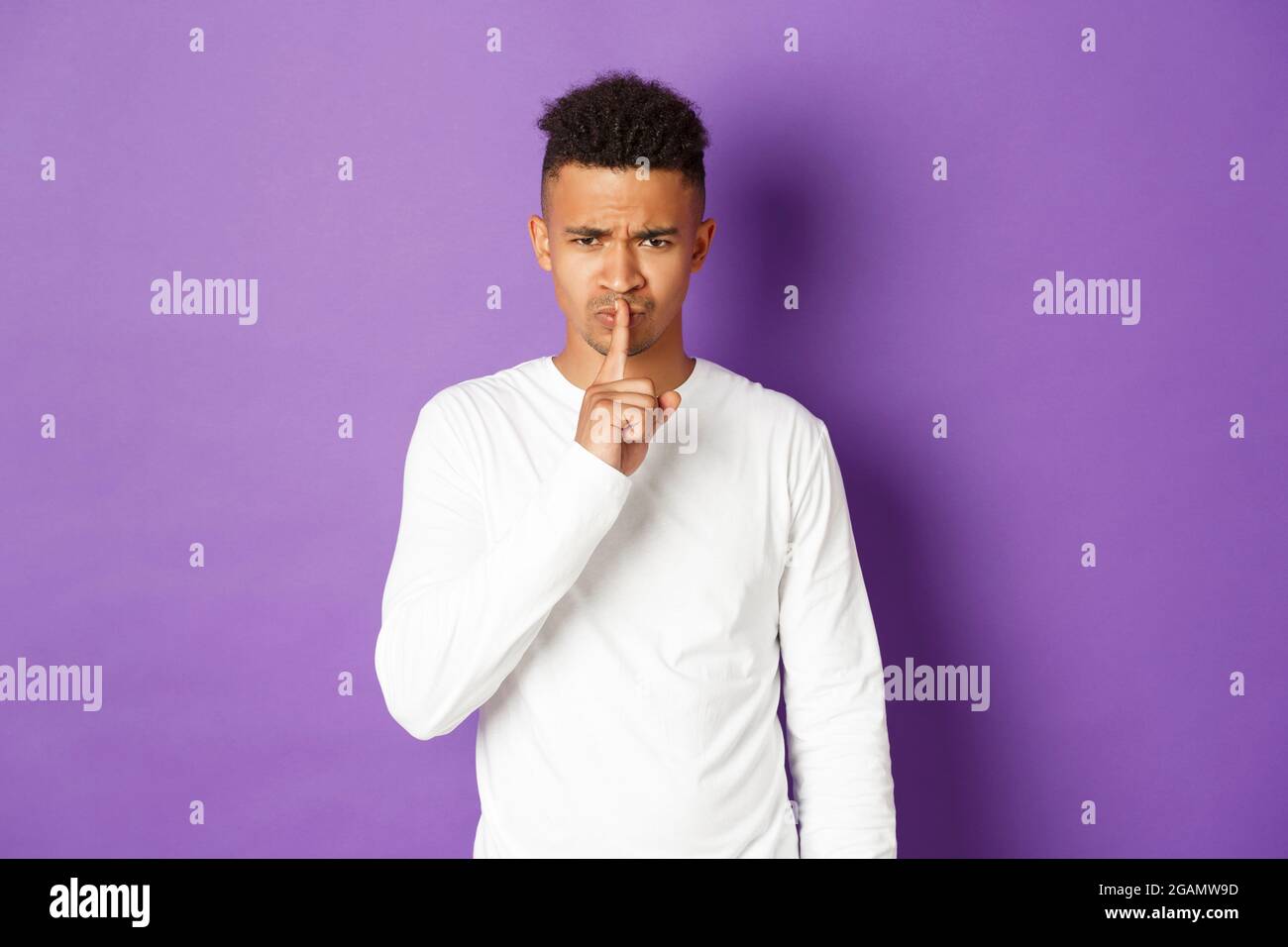 Image of angry african-american man hushing at you, press finger over ...