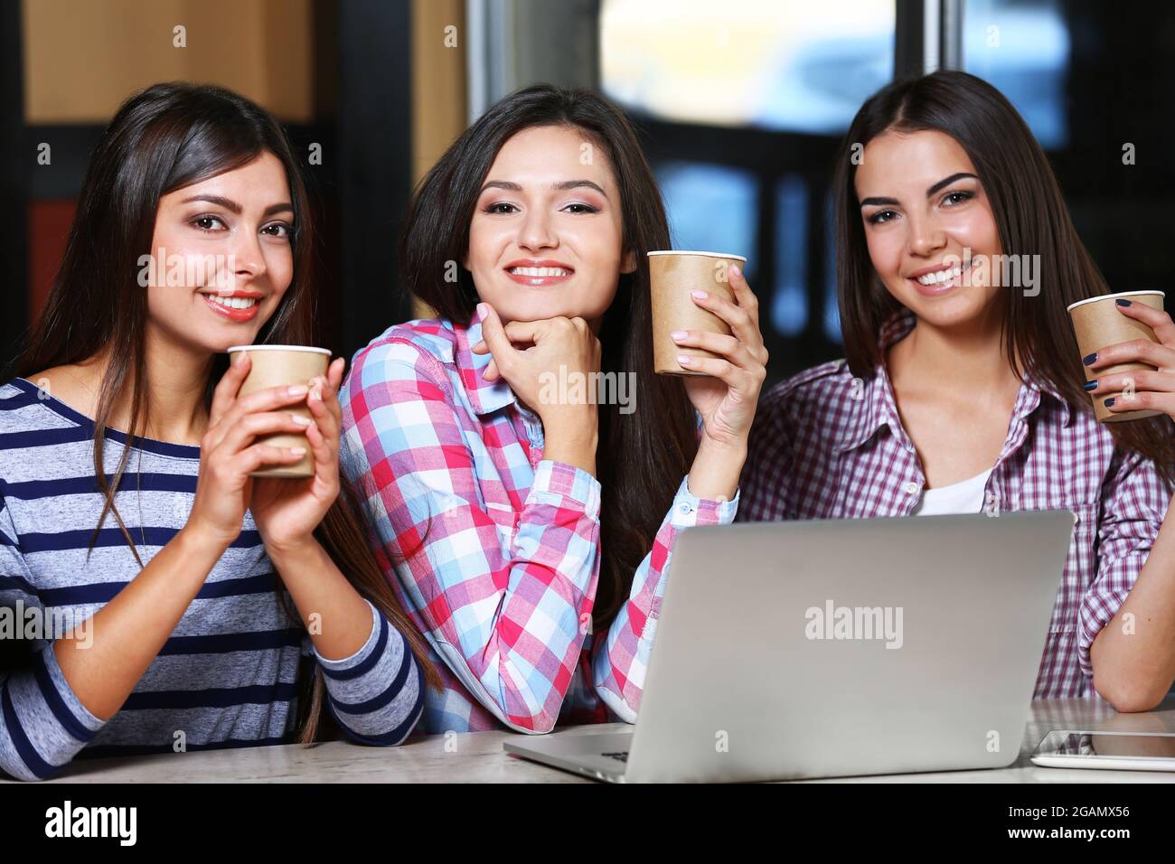 Best friends with laptop together sitting in cafe Stock Photo - Alamy