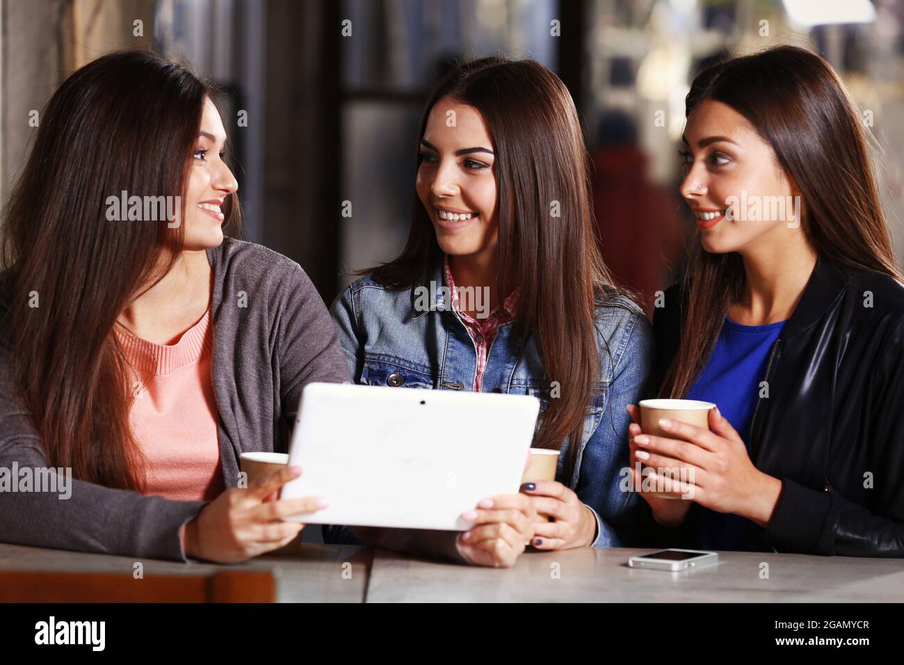 Best friends with tablet together sitting at cafes terrace Stock Photo ...