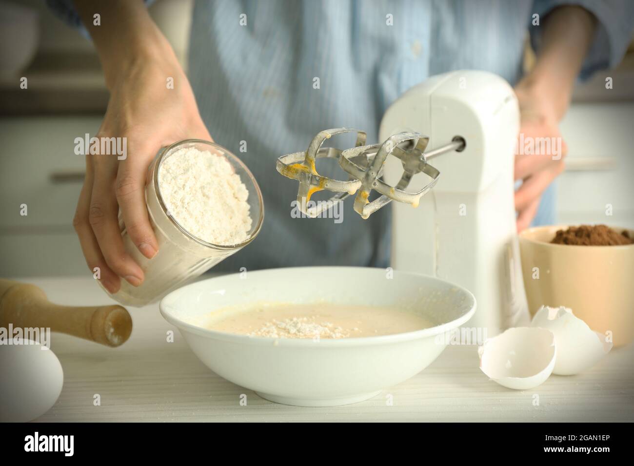 Woman is adding flour to the mixture Stock Photo - Alamy
