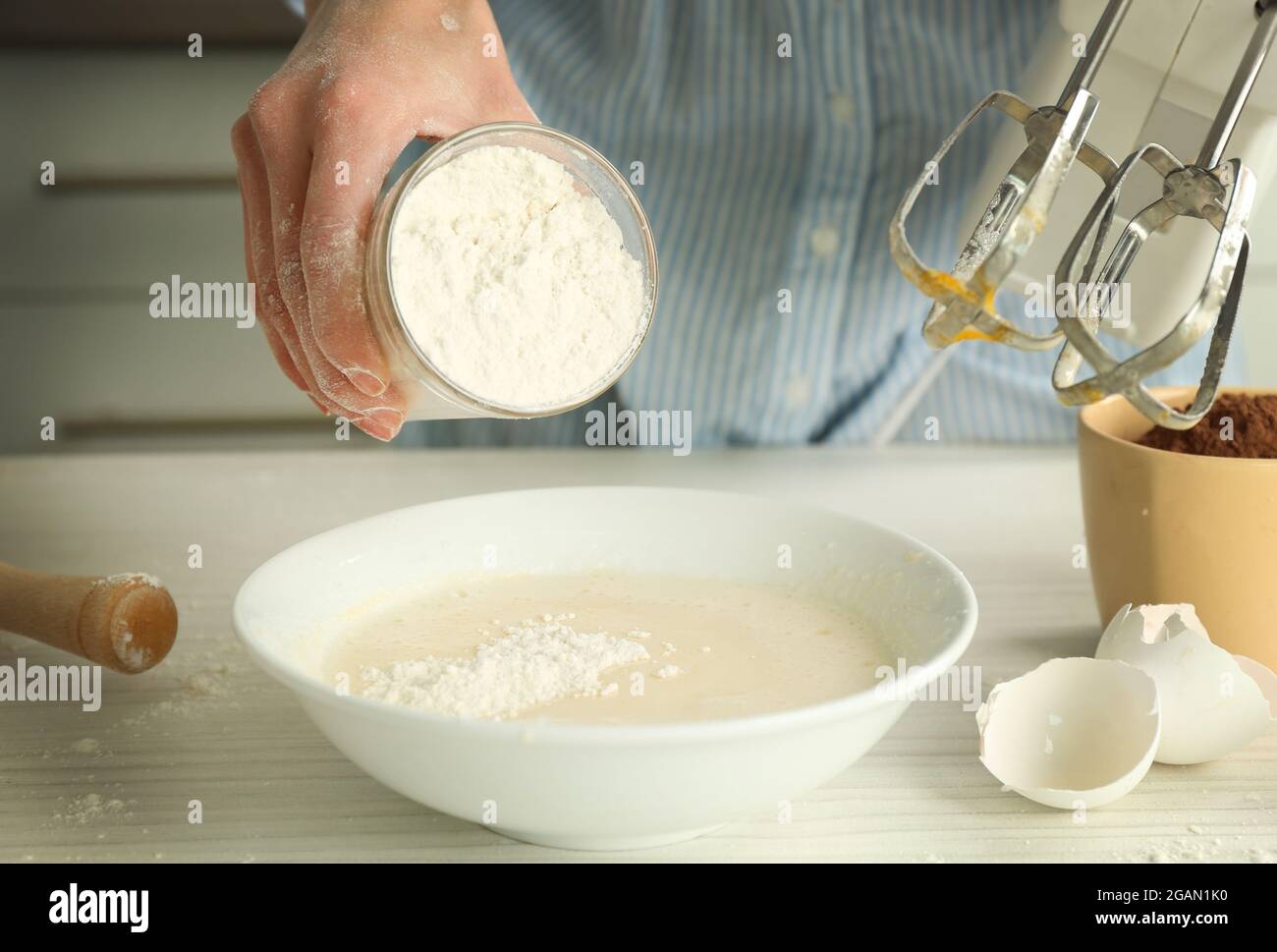 Woman is adding flour to the mixture Stock Photo - Alamy