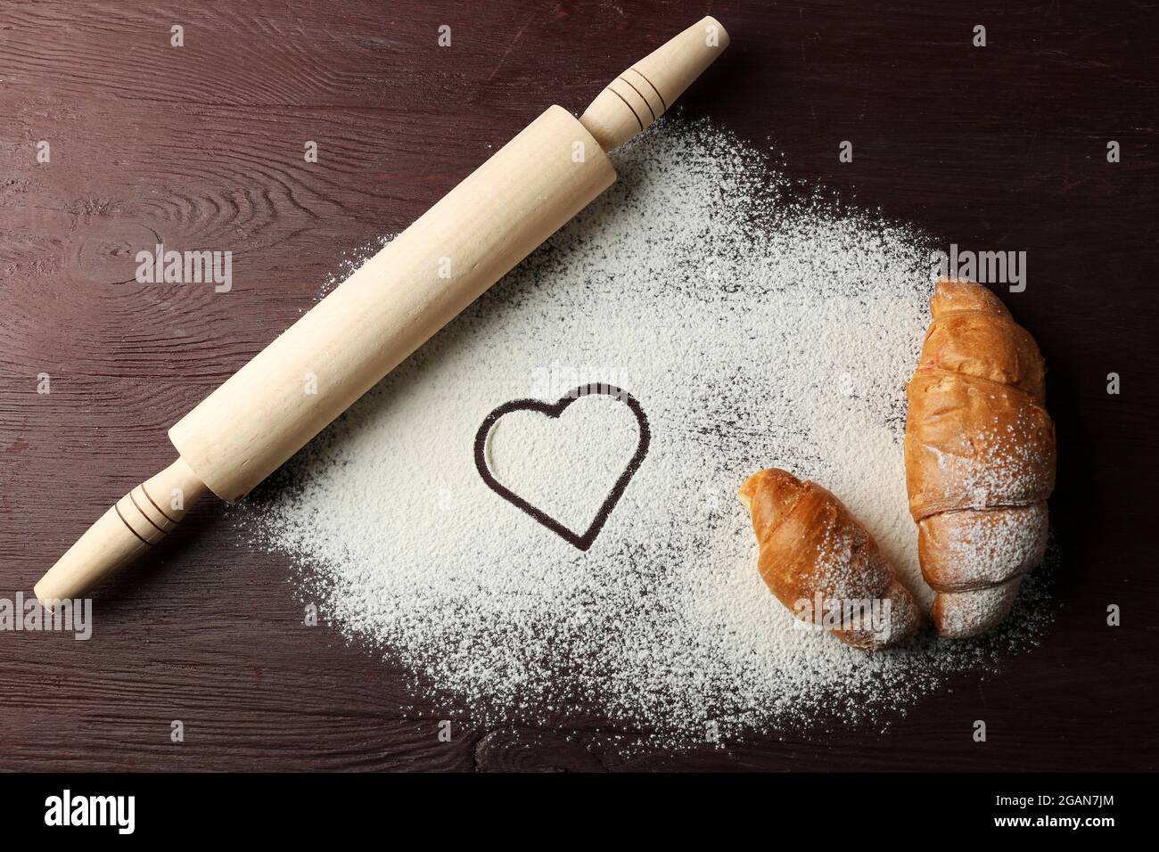 Heart of flour, croissants and rolling pin on table background Stock ...