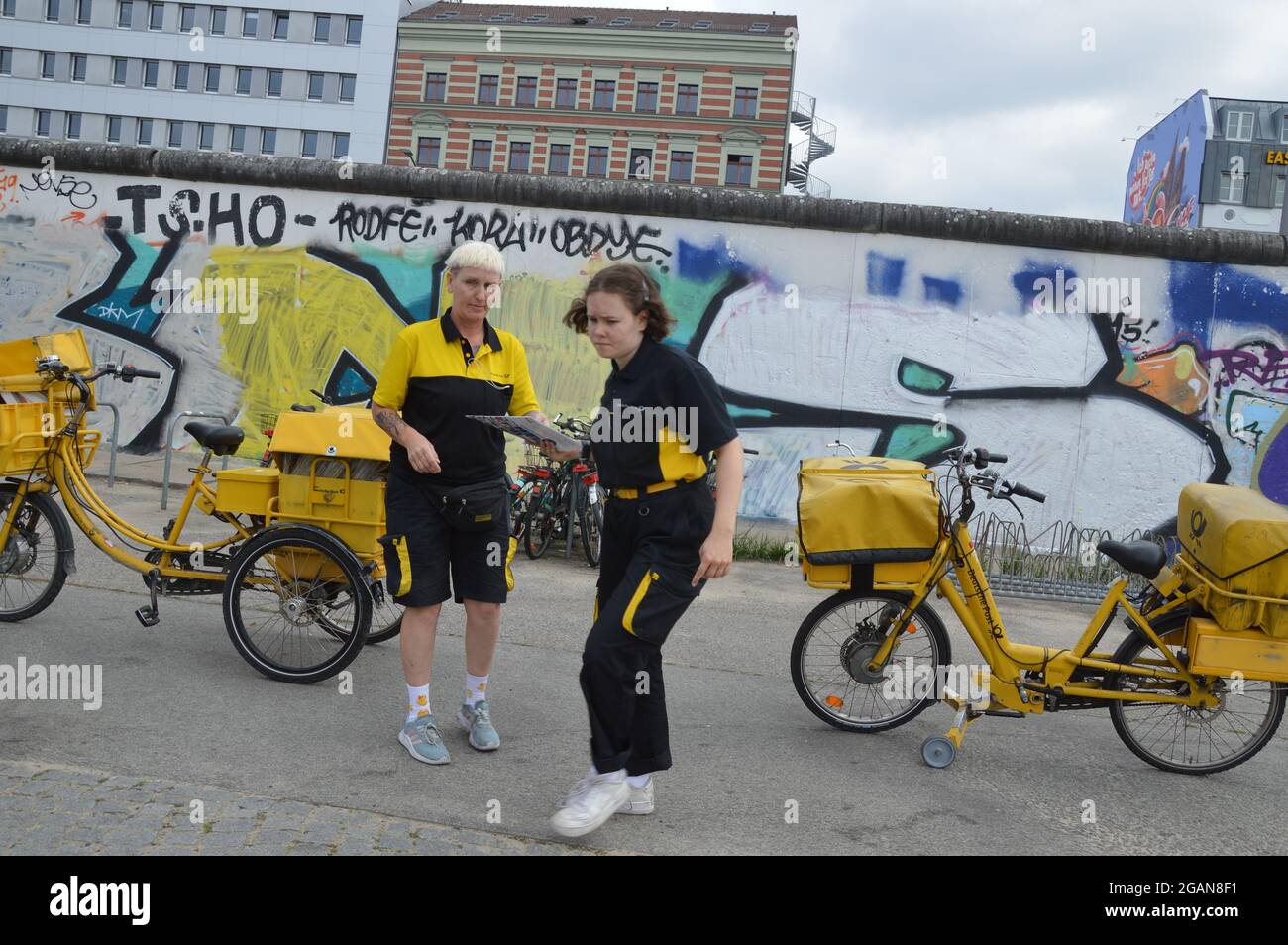 Two female mail carrier near the Berlin Wall in Friedrichshain, Berlin ...