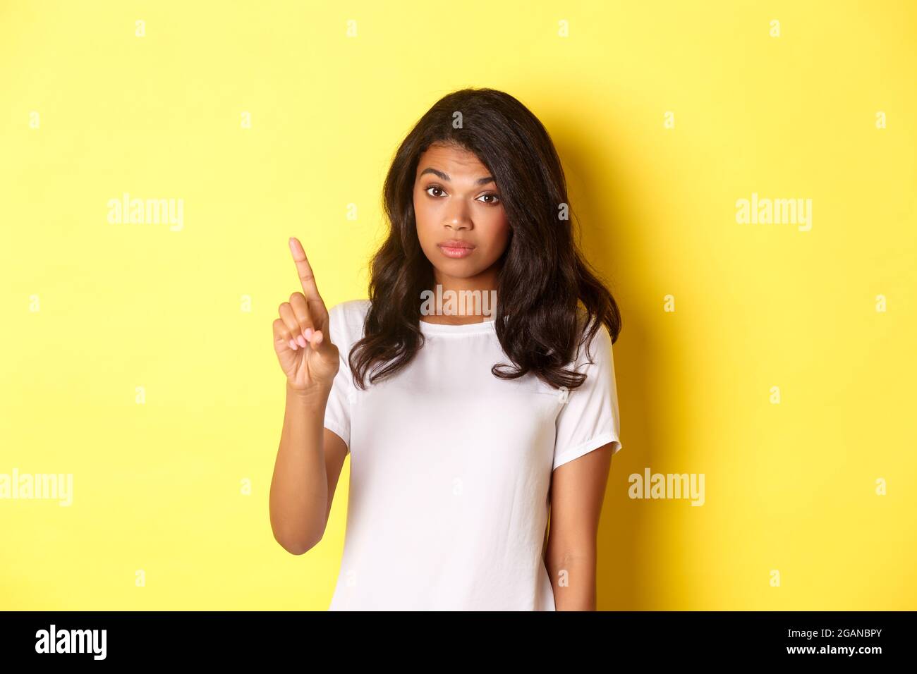 Image of serious african-american girl, scolding someone, raising one ...