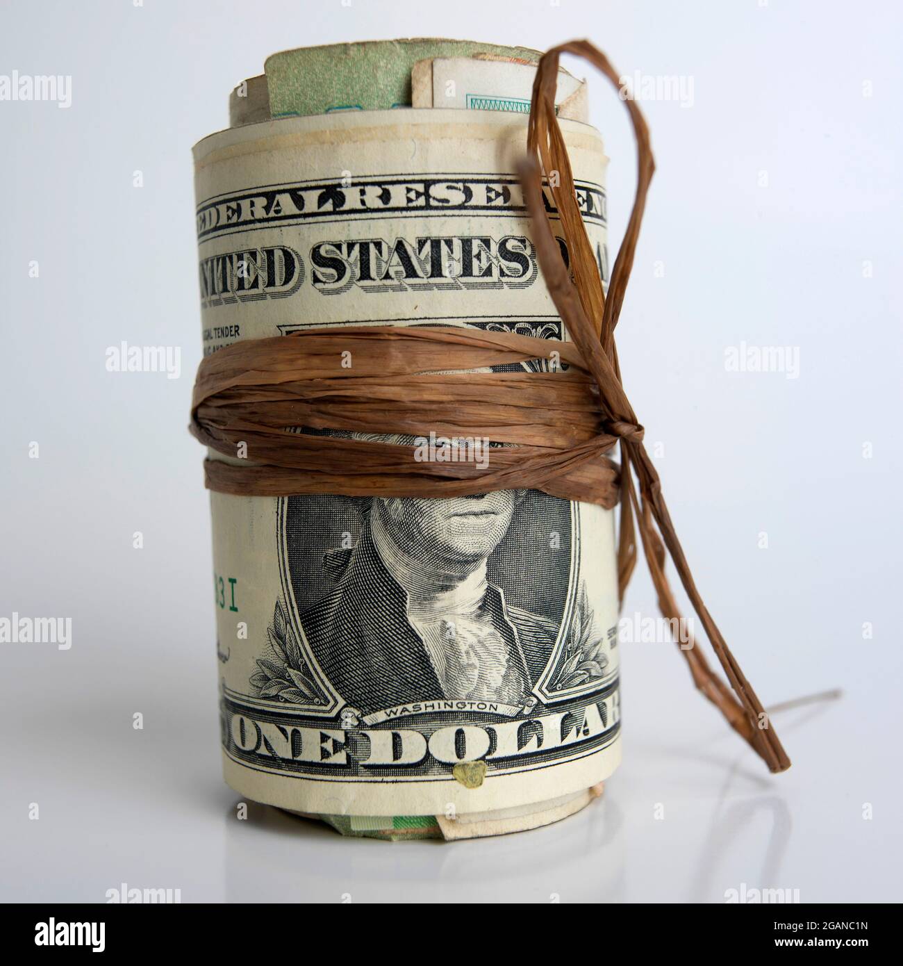 A bundle of one-dollar bills tied with twine captured in a minimalistic ...