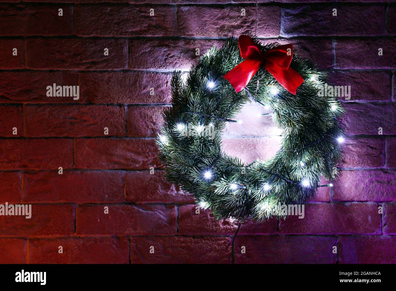 Christmas wreath on a brick wall background Stock Photo - Alamy