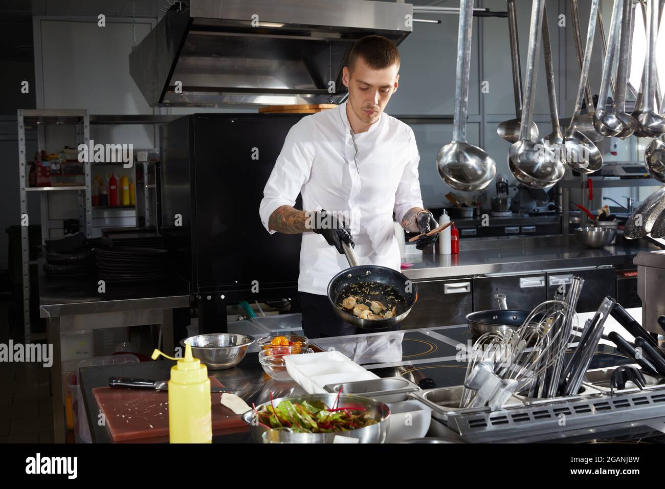 Chef cooking in the modern kitchen in hotel restaurant, preparing ...