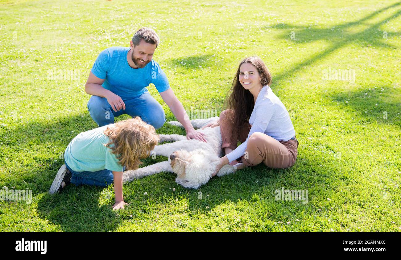happy family of mother dad and child son playing with pet dog in summer ...