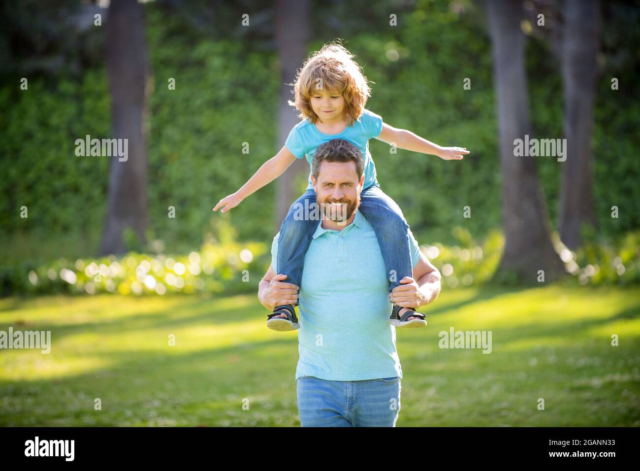 Ill give a piggy-back ride. Happy man carry son sitting on shoulders ...