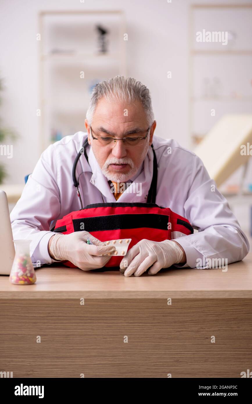 Old doctor in first aid concept Stock Photo - Alamy
