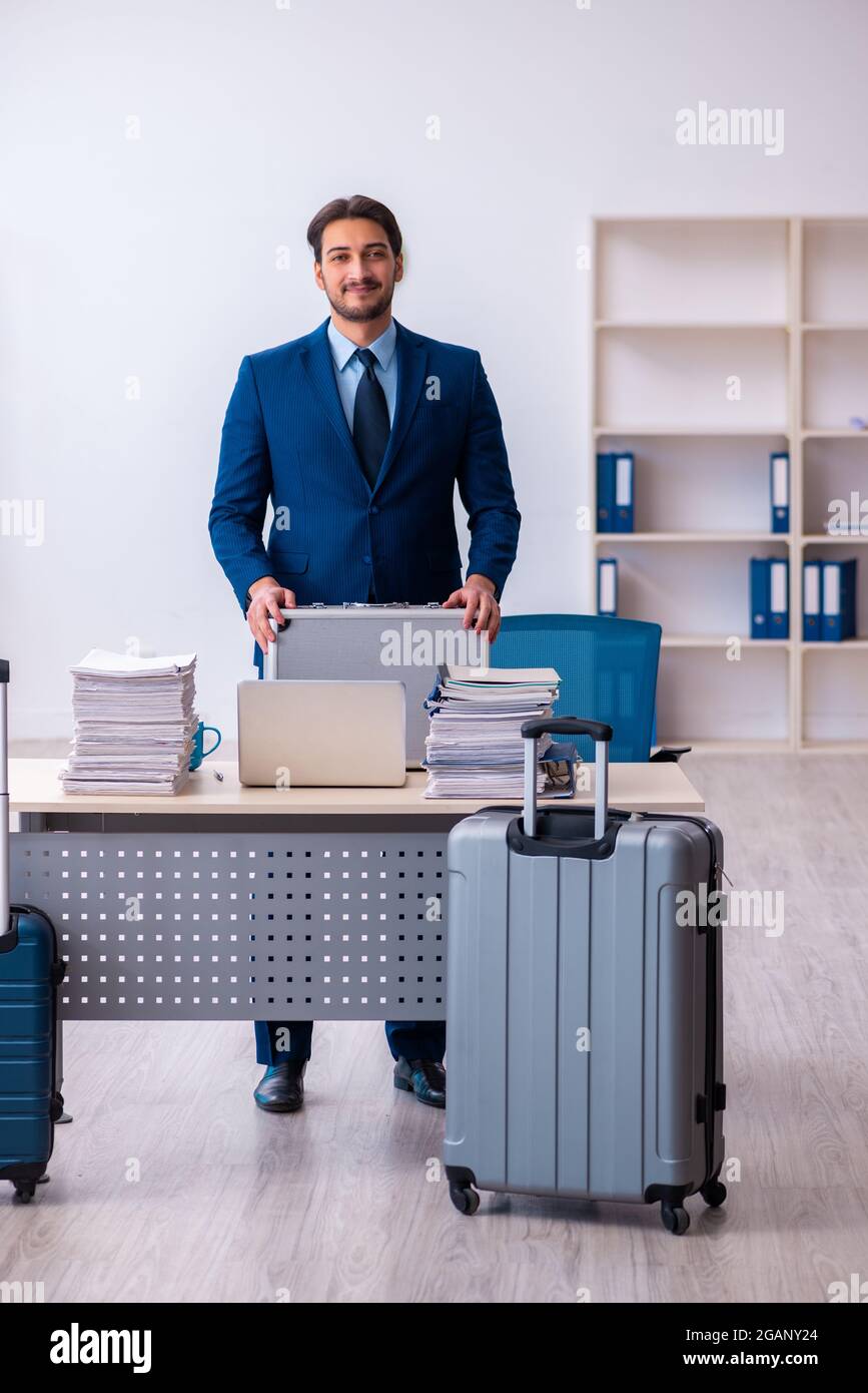 Young businessman employee preparing for business trip at workplace ...