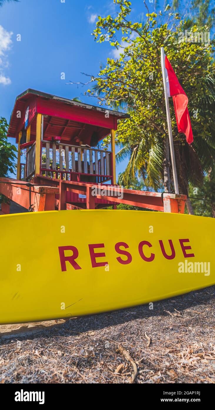 Red Lifeguard tower and yellow rescue board with red warning flag Stock ...