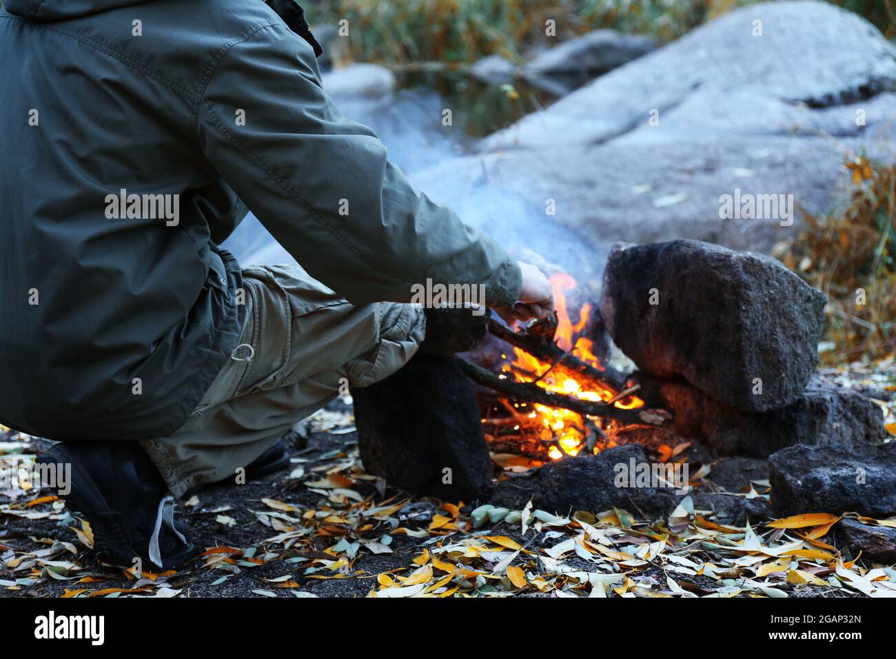 Man making fire in mountains Stock Photo - Alamy