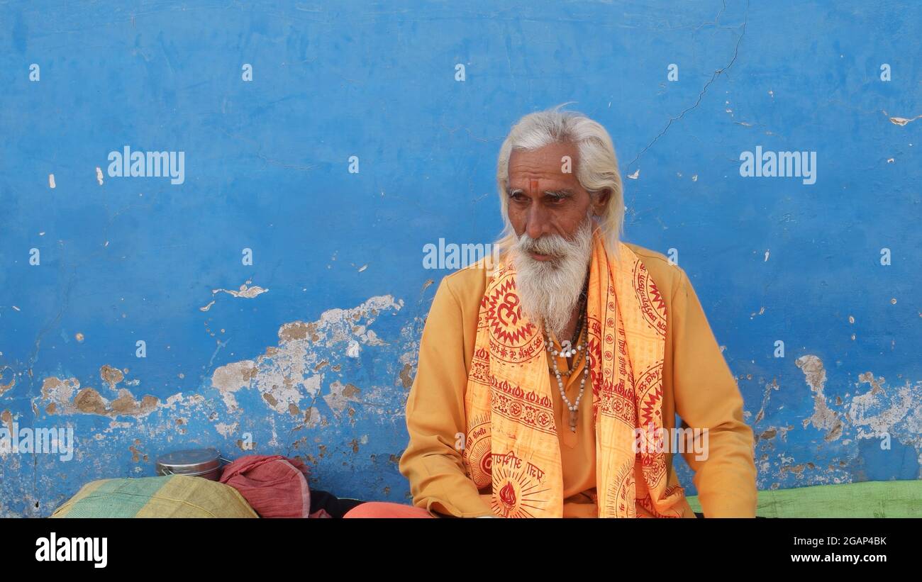 A religious ascetic Sadhu in traditional Indian clothes sitting outdoor ...