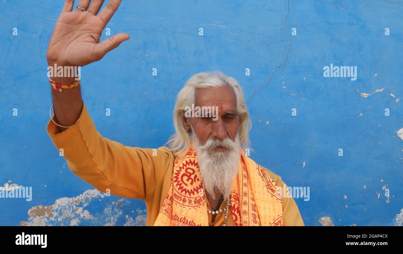 A religious ascetic Sadhu in traditional Indian clothes sitting outdoor ...