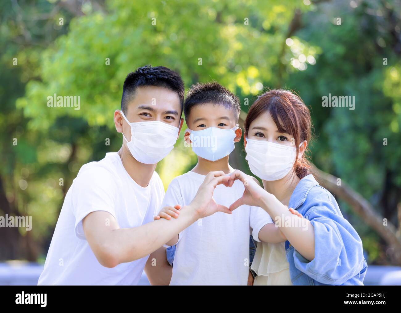 Happy family wearing protective medical masks for protection from covid ...